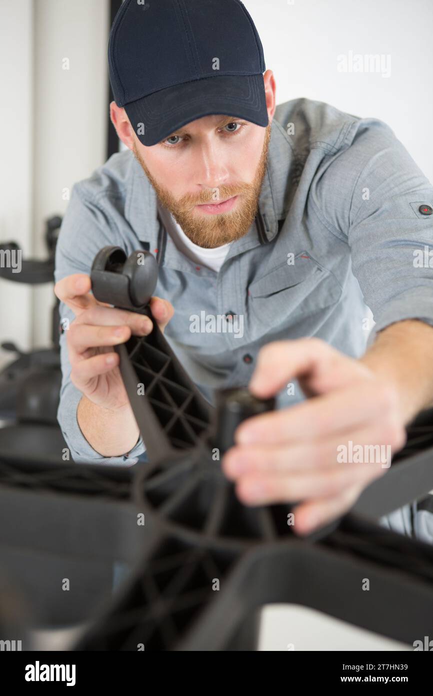 man during office chair wheel assembly Stock Photo - Alamy