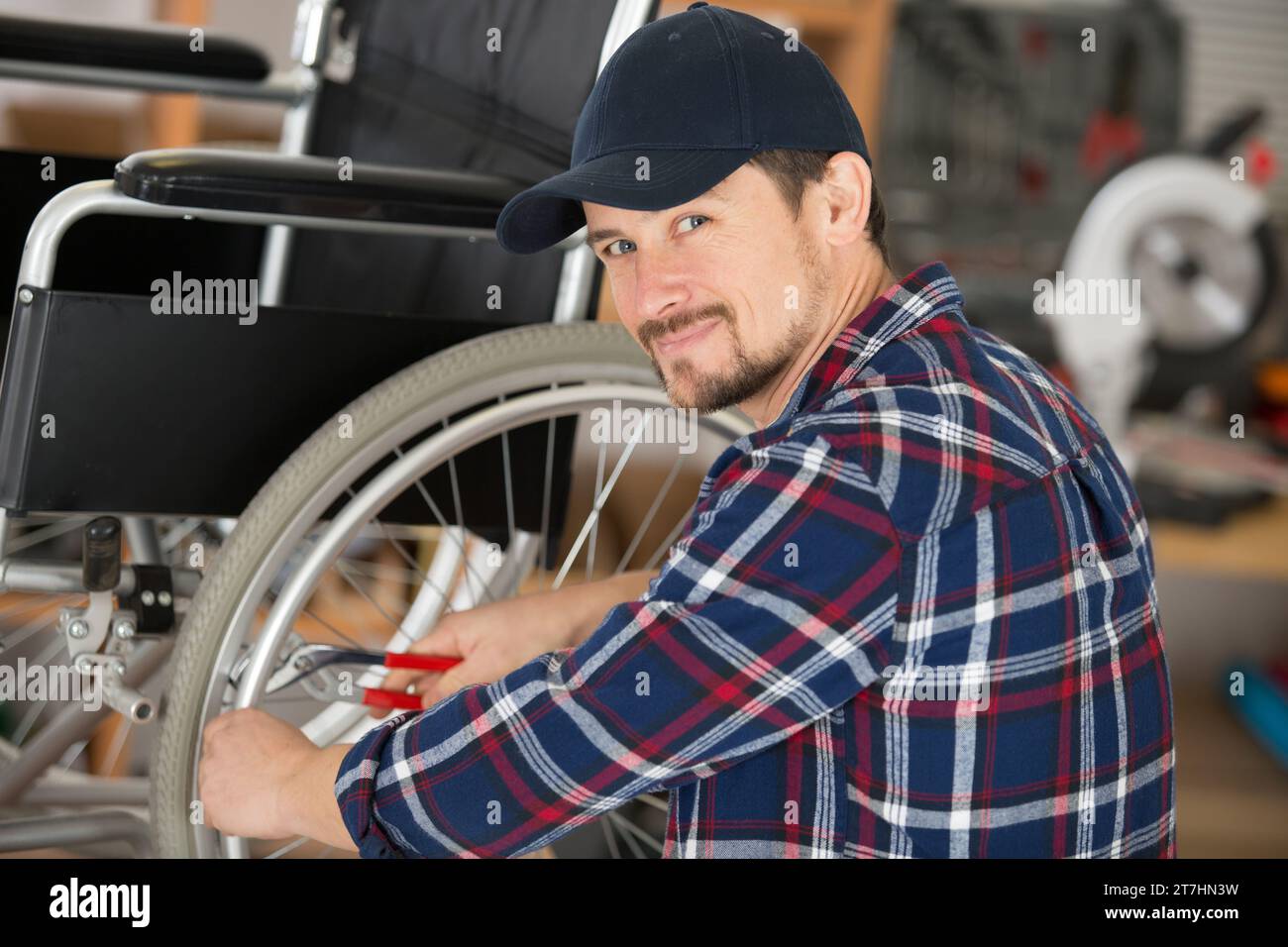 Young man fixing wheelchair hi-res stock photography and images - Alamy