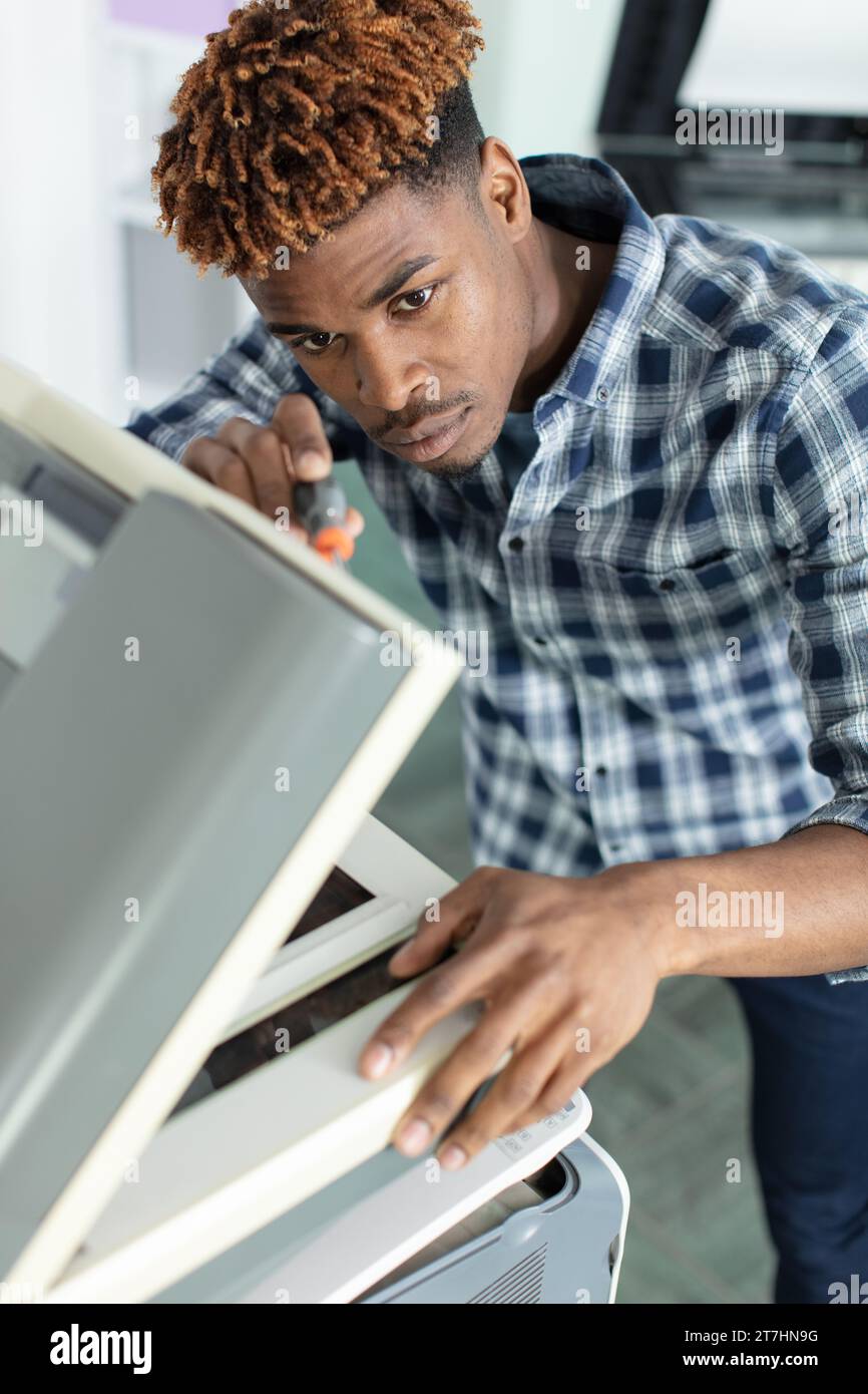 a young man is fixing a printer Stock Photo - Alamy
