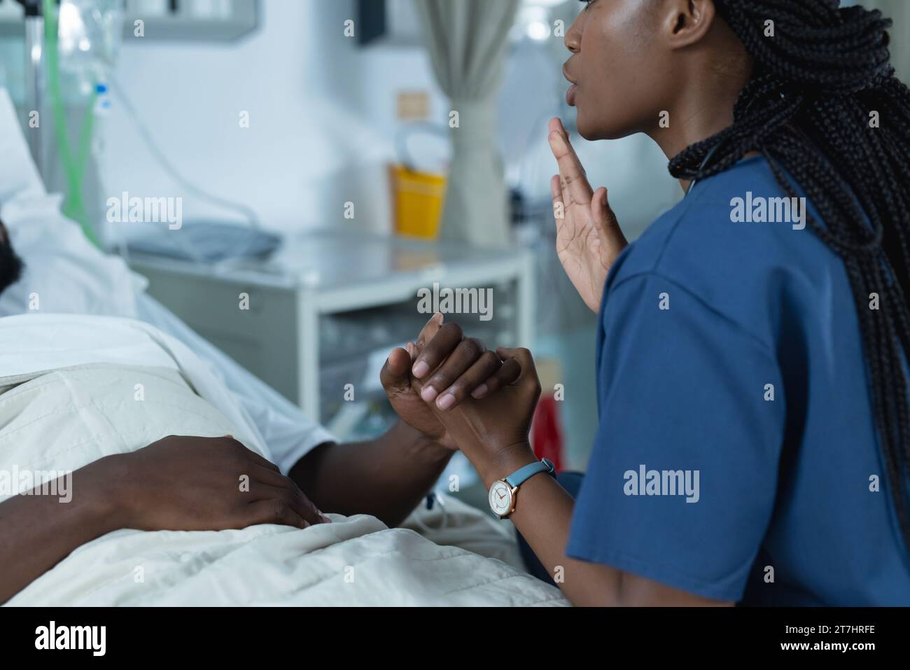 African american female doctors and male patient is lying in bed ...