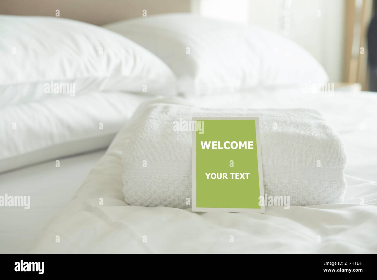 Welcome card placed inside a hotel room bed with green apple. With ...