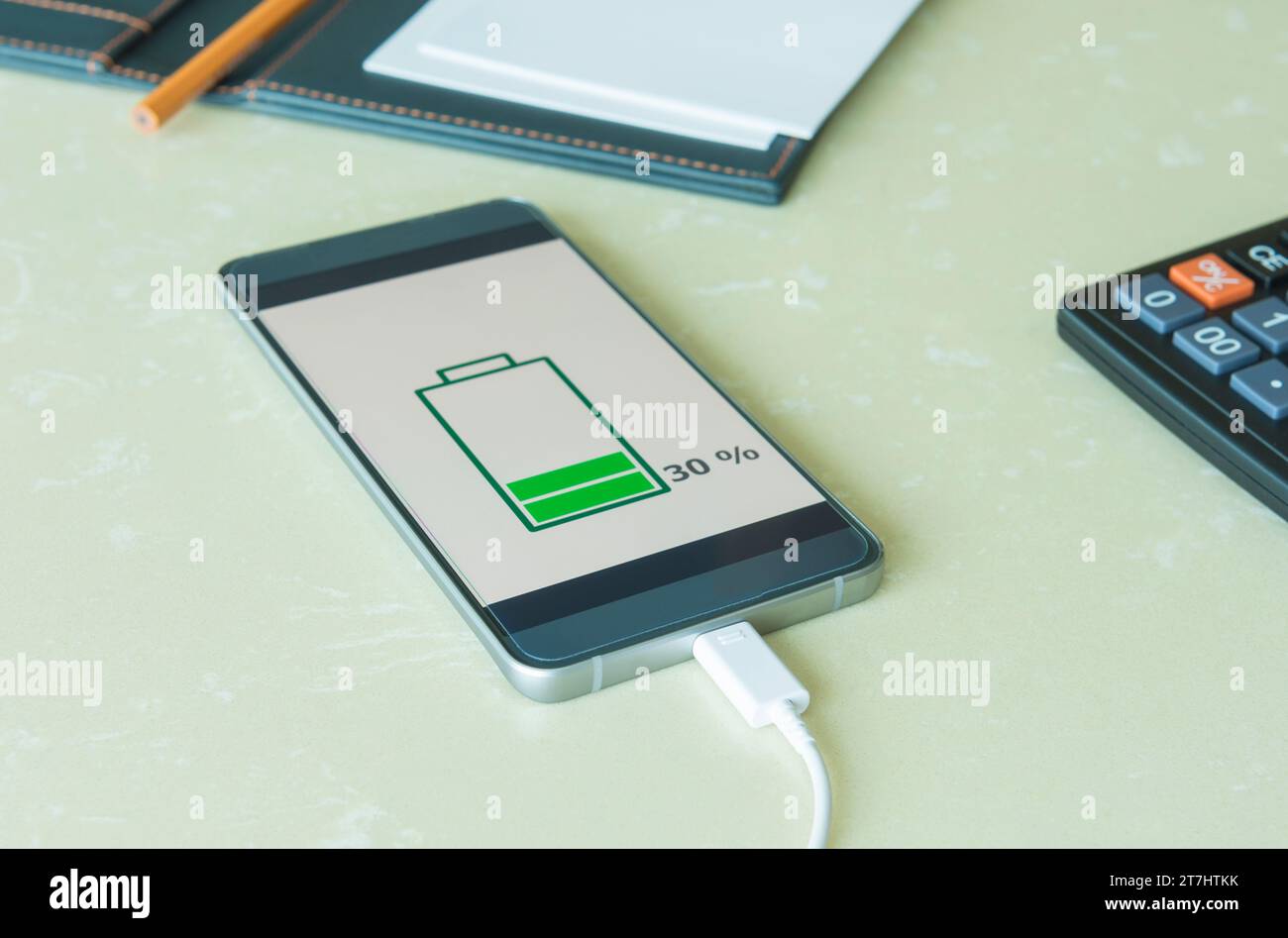 Mobile smart phones charging on wooden desk Stock Photo - Alamy