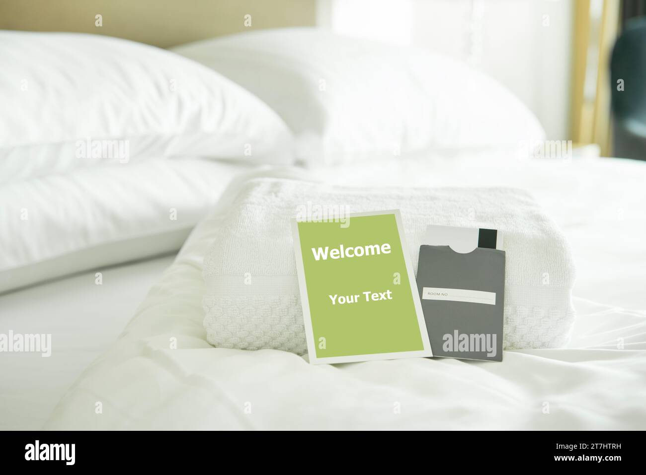 Welcome card placed inside a hotel room bed with White towel and card ...