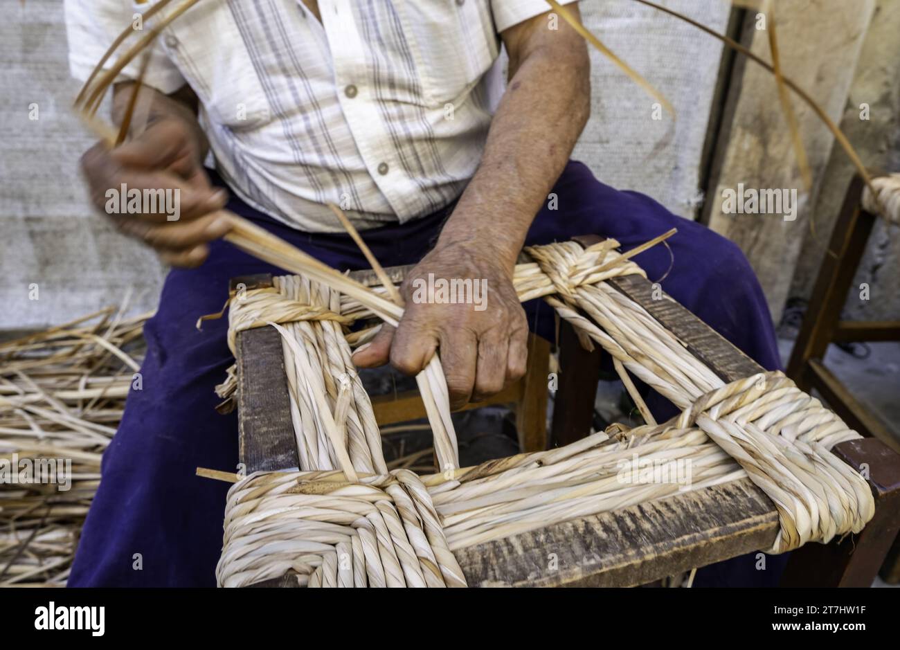 Detail of older man working dry wicker with his hands, crafts Stock ...
