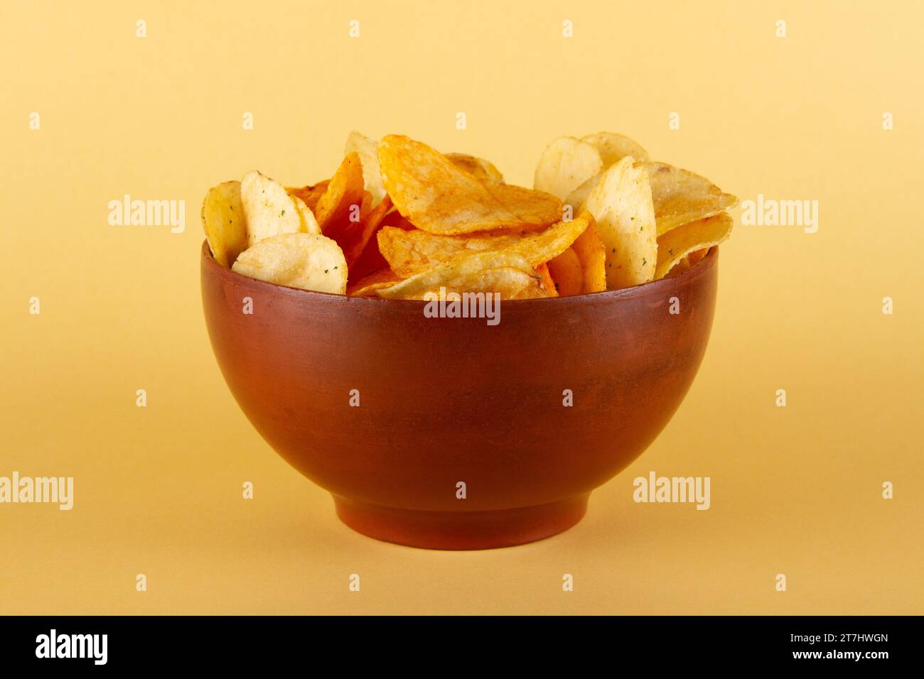 Potato chips in clay bowl isolated on beige background. side view Stock ...