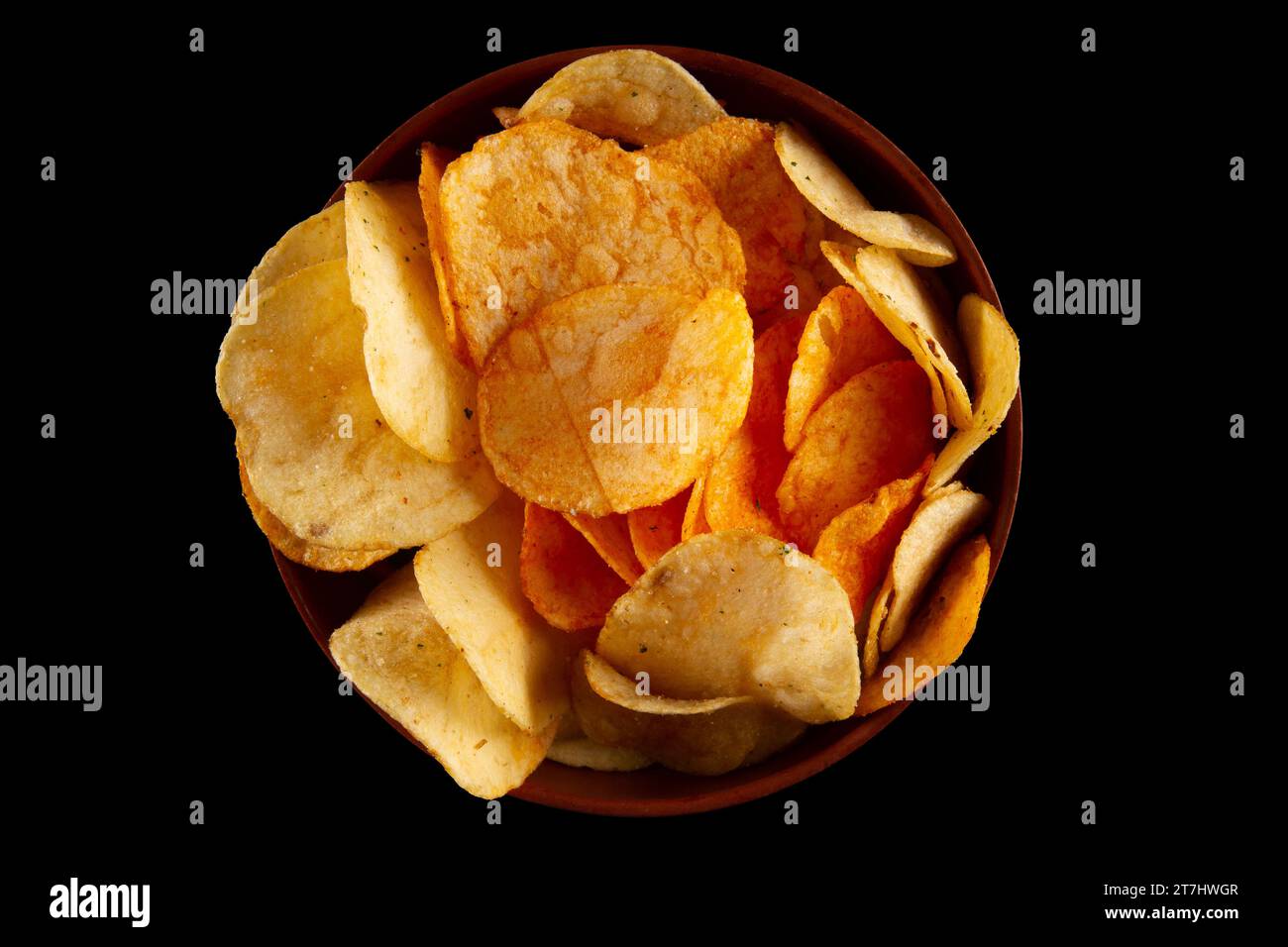 Potato chips in clay bowl isolated on black background. Top view Stock ...