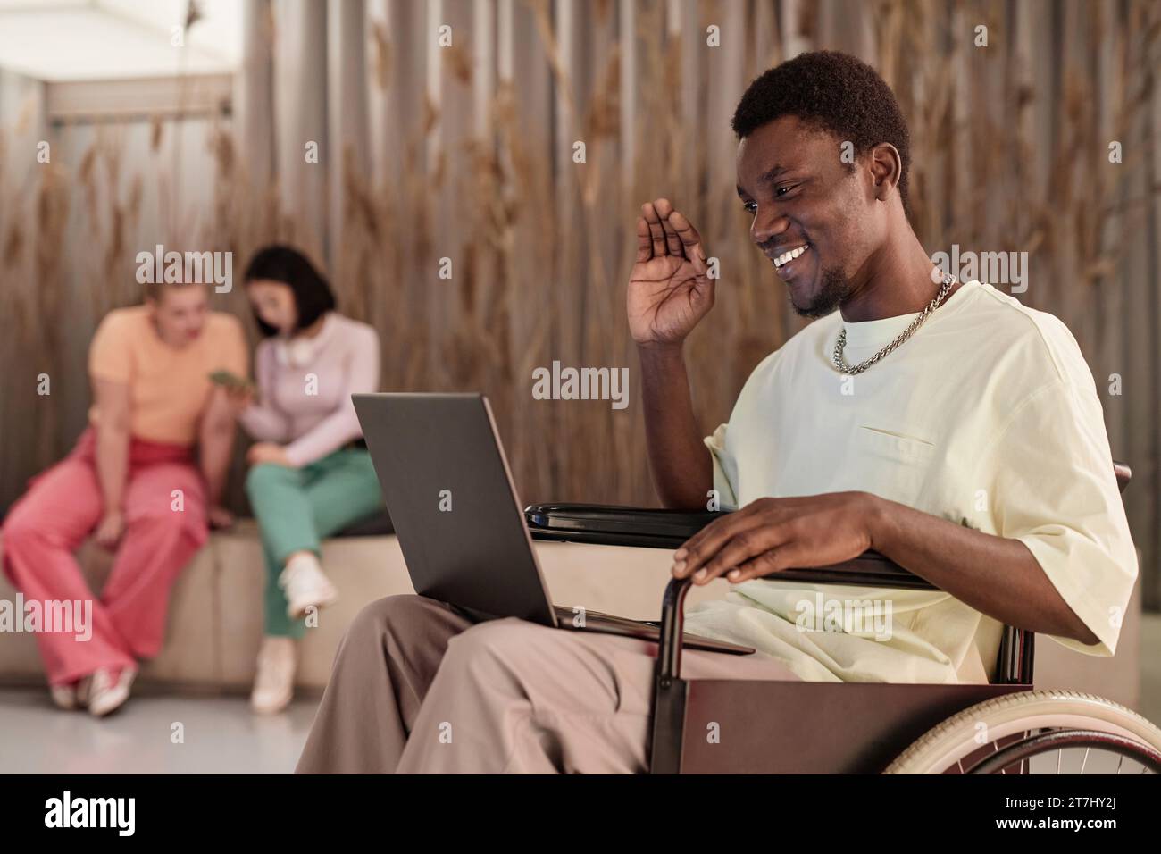 Side view portrait of young Black man with disability waving at ...