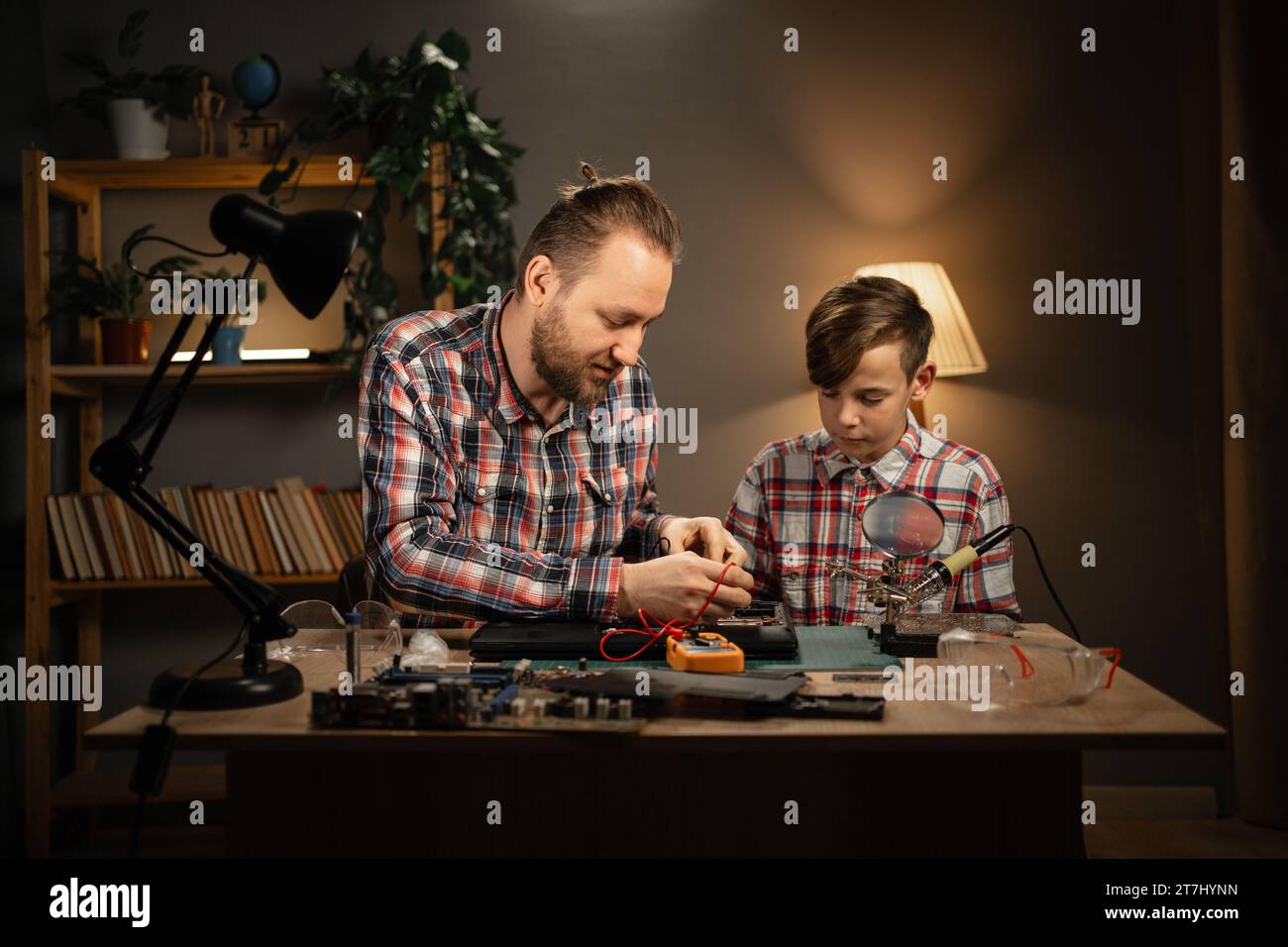 Father and his son using soldering iron and multimeter for fixing ...