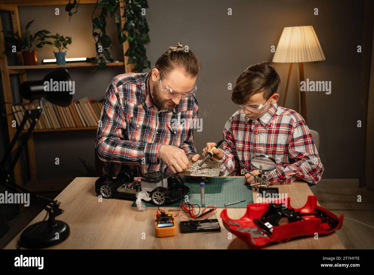 Dad And Son Wear And Eyeglasses Working With Soldering Iron While