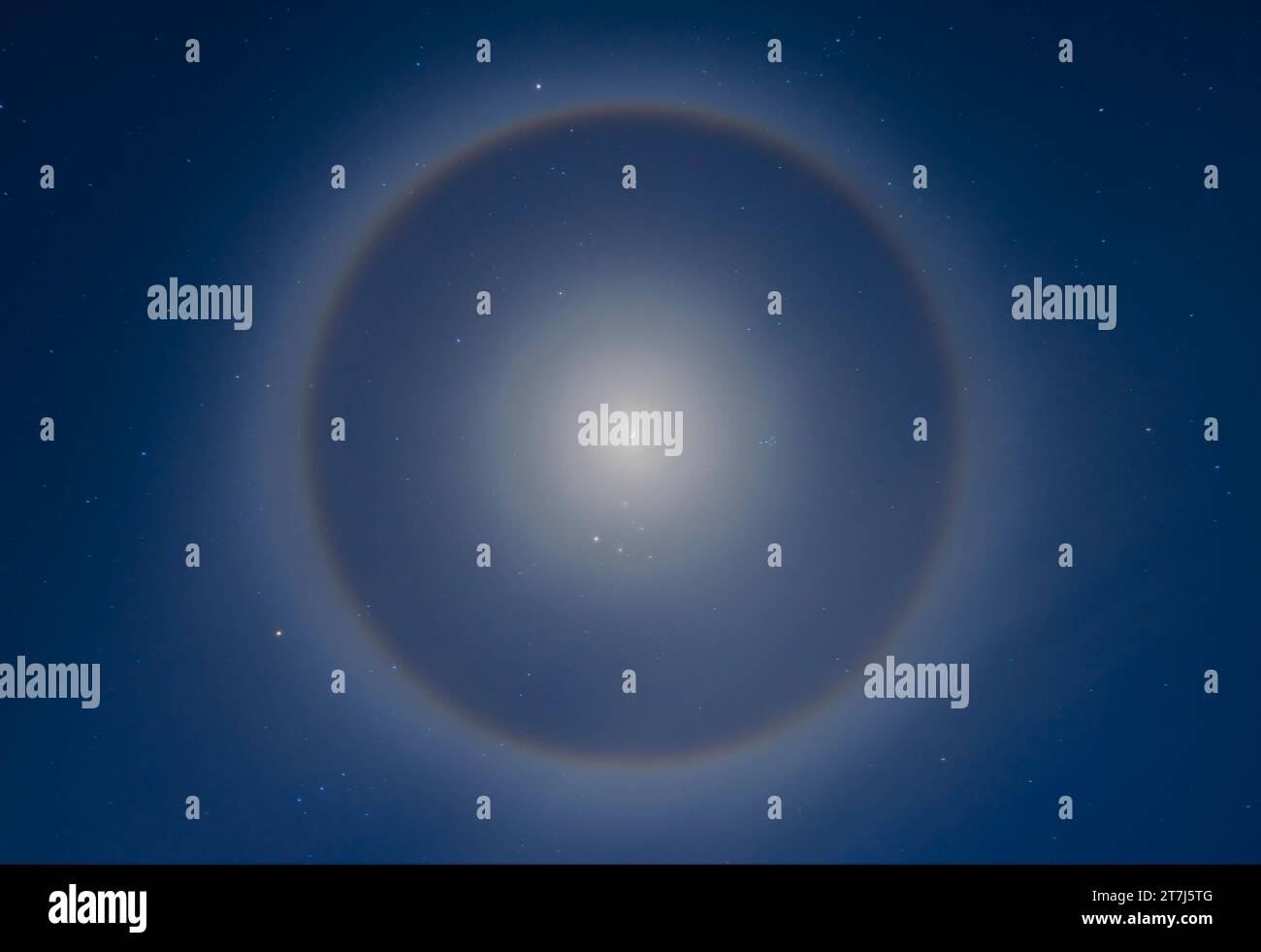 An ice crystal halo around the waxing gibbous Moon set in the winter ...