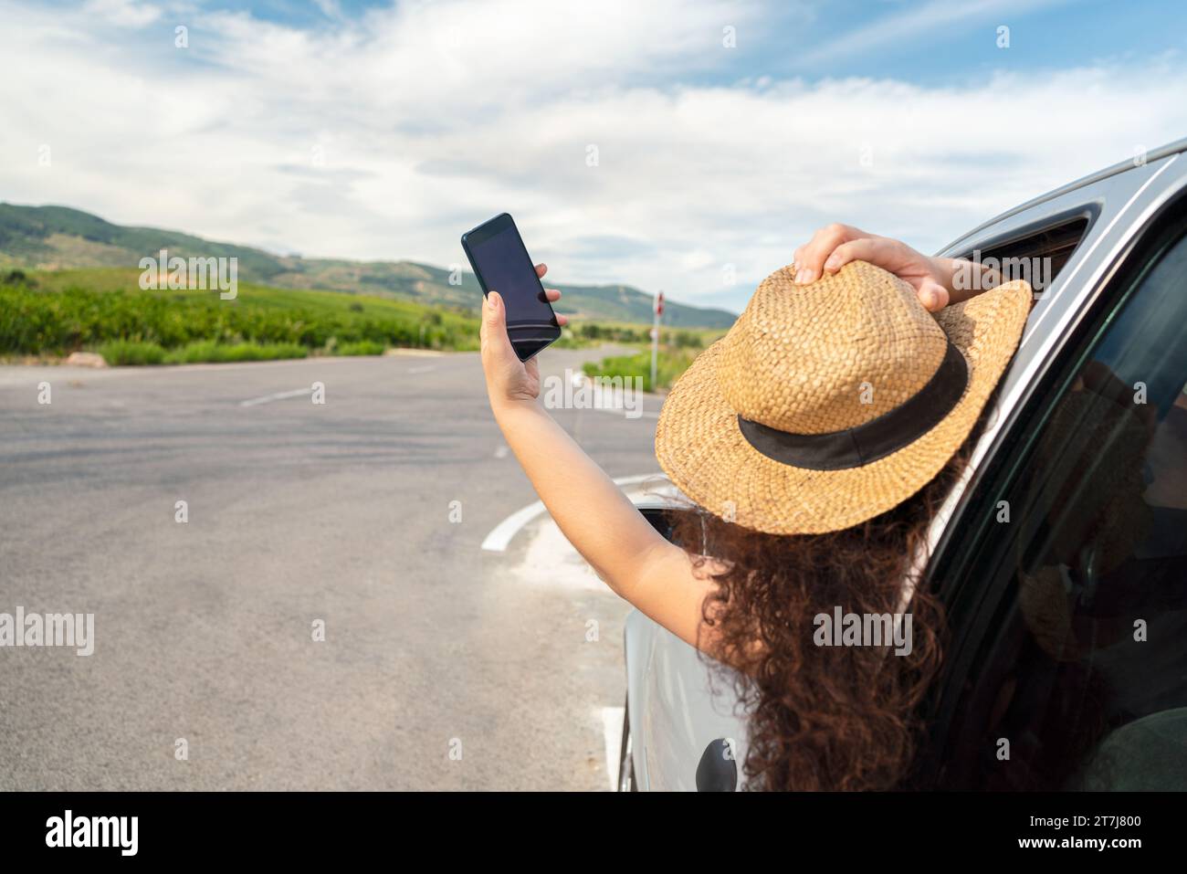Hand with a smartphone searching for signal from a car on a highway ...