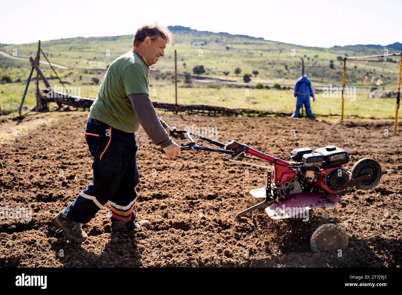 A farmer man plows the land with a cultivator. Machinery cultivator for ...
