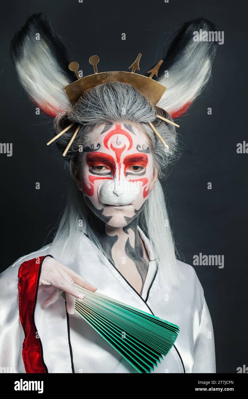 Attractive actress woman with stage makeup, rabbit mask and costume ...