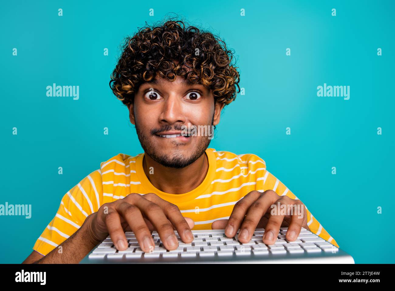 Portrait of puzzled nervous african man biting lips fingers typing ...