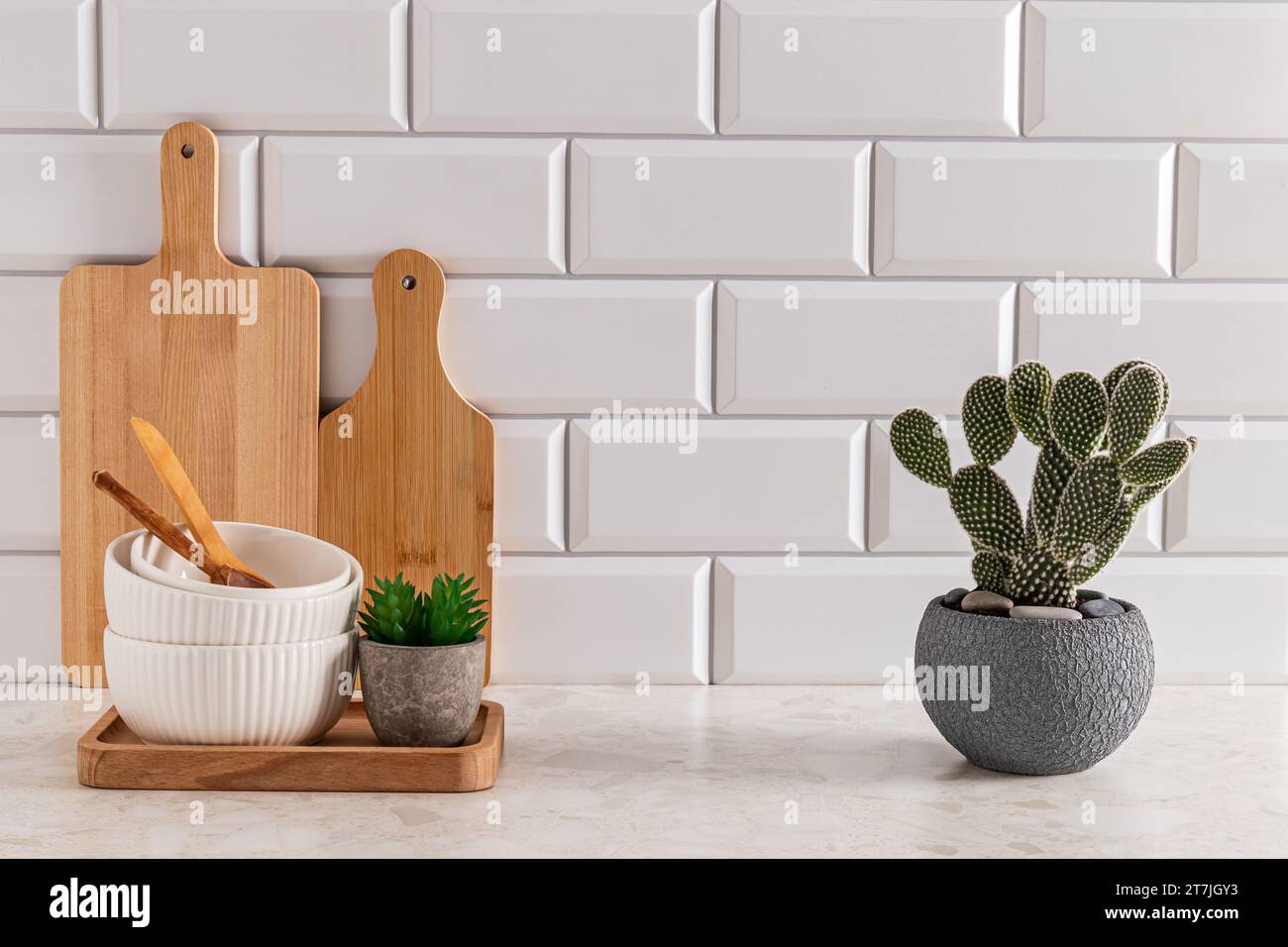 Set of ceramic bowls and cutting boards on stone light countertop in ...