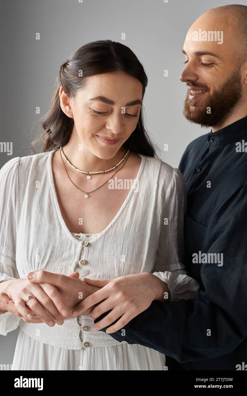 vertical shot of happy loving couple in stylish classy attires hugging ...