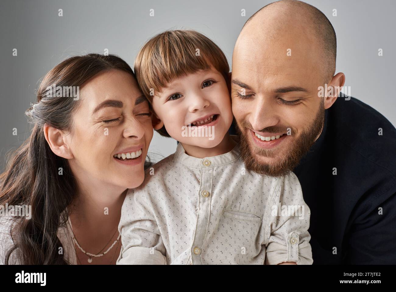 joyous loving parents smiling with closed eyes hugging their joyful ...