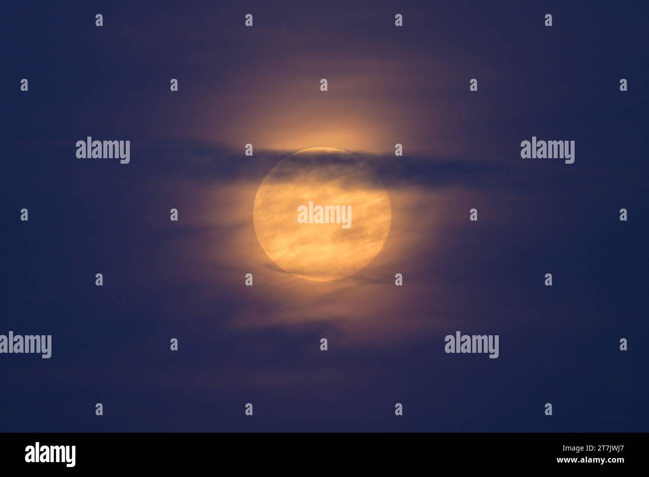 Yellow full moon behind clouds in northern France in summer Stock Photo ...
