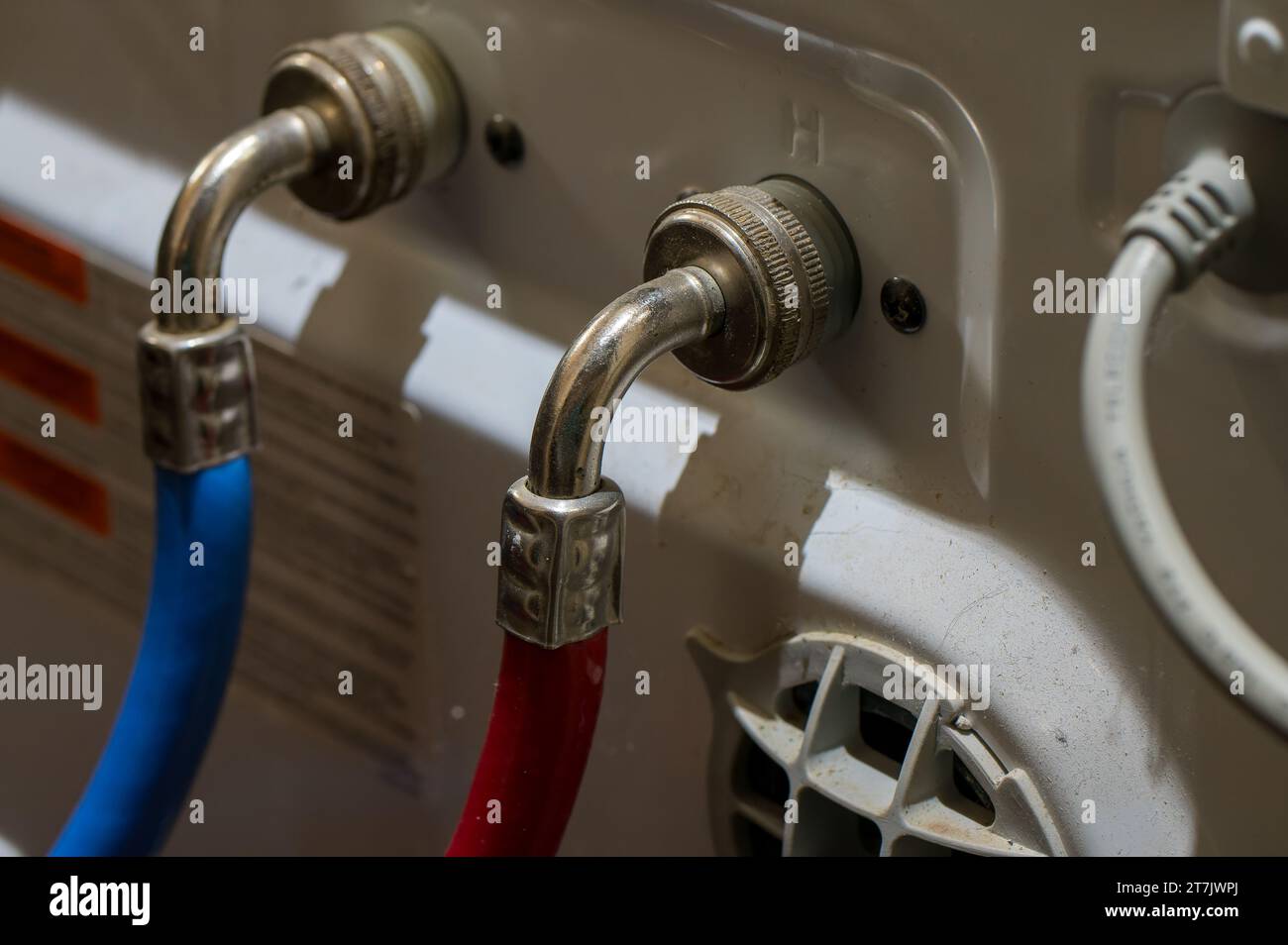 A close up of a hot water line attached to a washing machine Stock ...