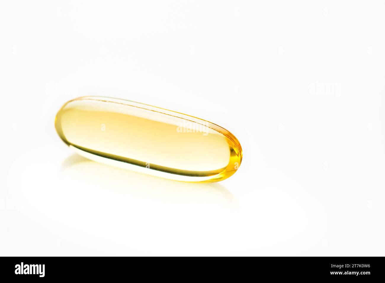 Capsules. Yellow pills isolated on white. Close up capsules with ...