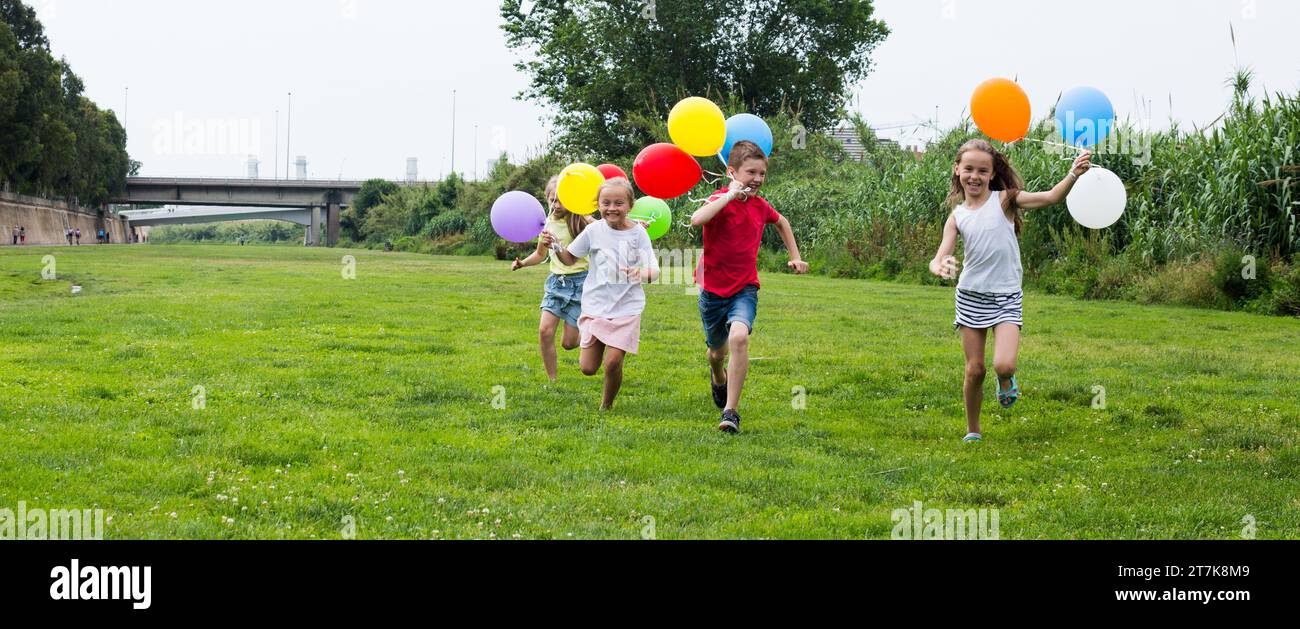 Children with balloons run in the summer park Stock Photo - Alamy