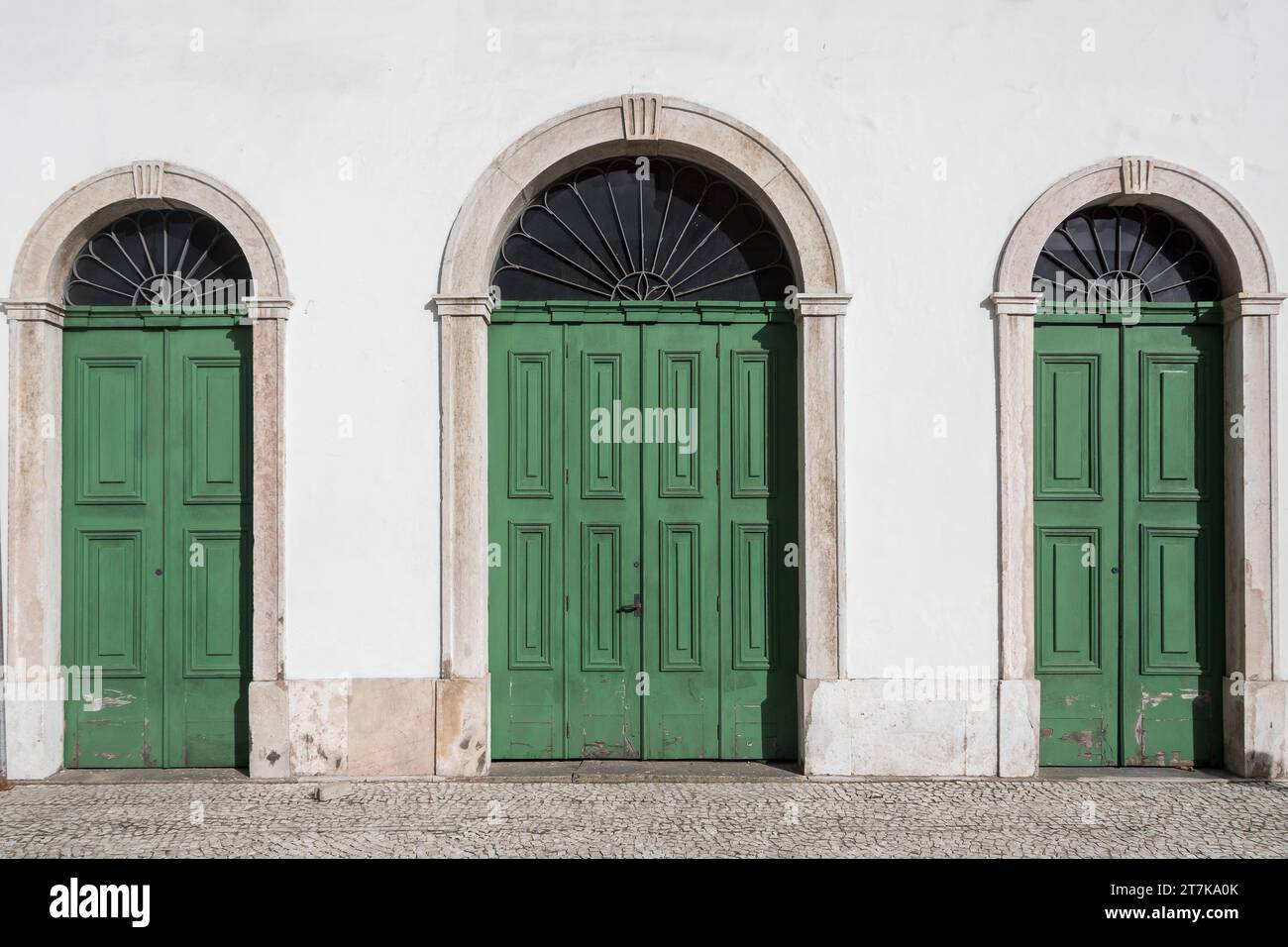 Old colonial facade with three green wooden doors Stock Photo - Alamy