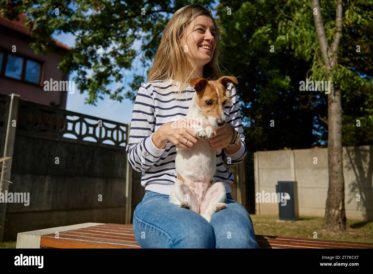 Woman has fun with dog. Female owner is spending time together with pet ...