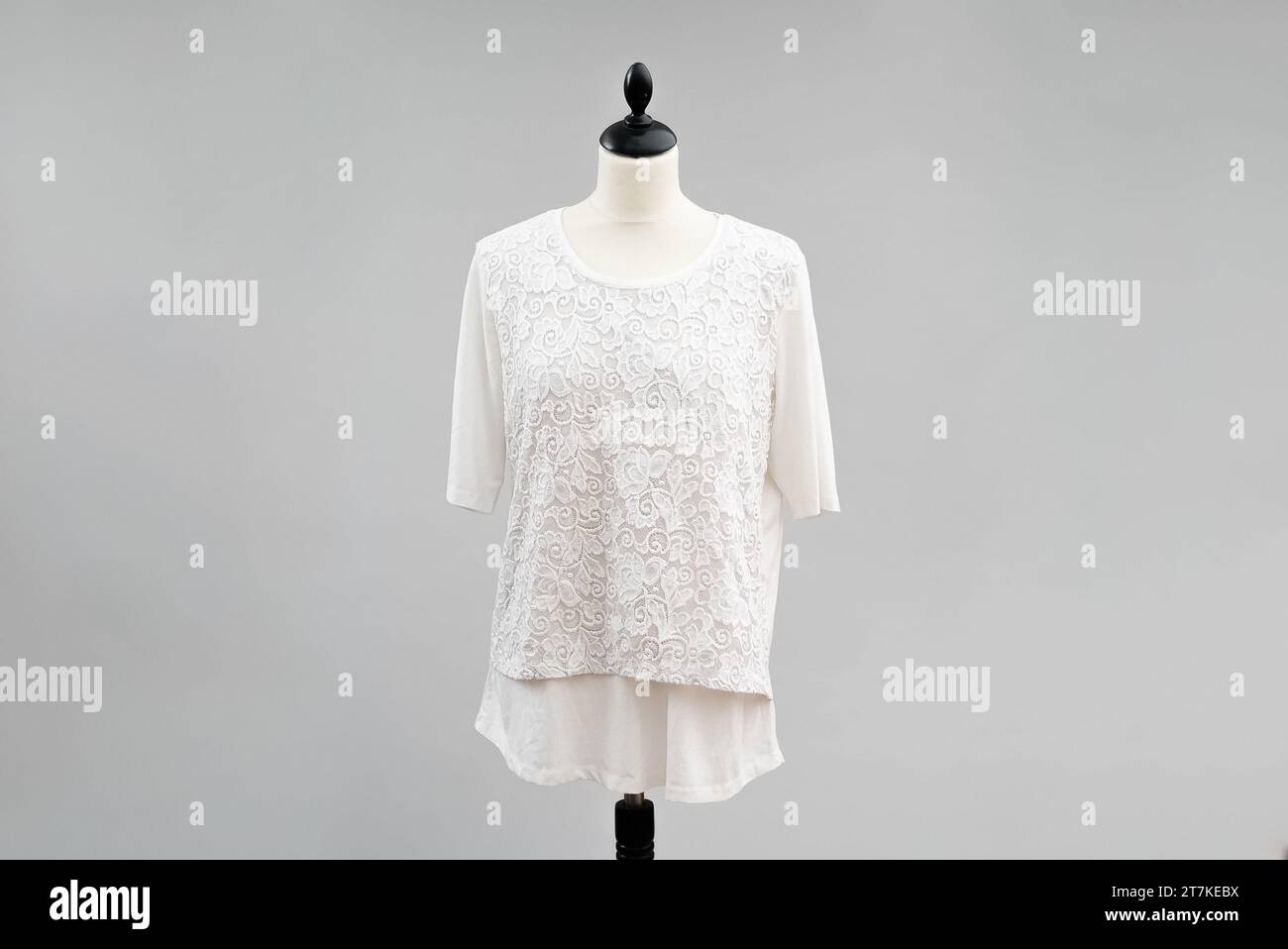 White top t-shirt with lace hanging on a headless mannequin Stock Photo ...