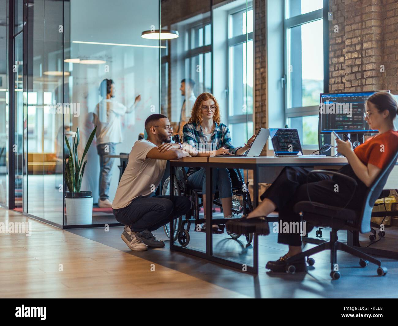 A diverse group of young business individuals congregates in a modern ...