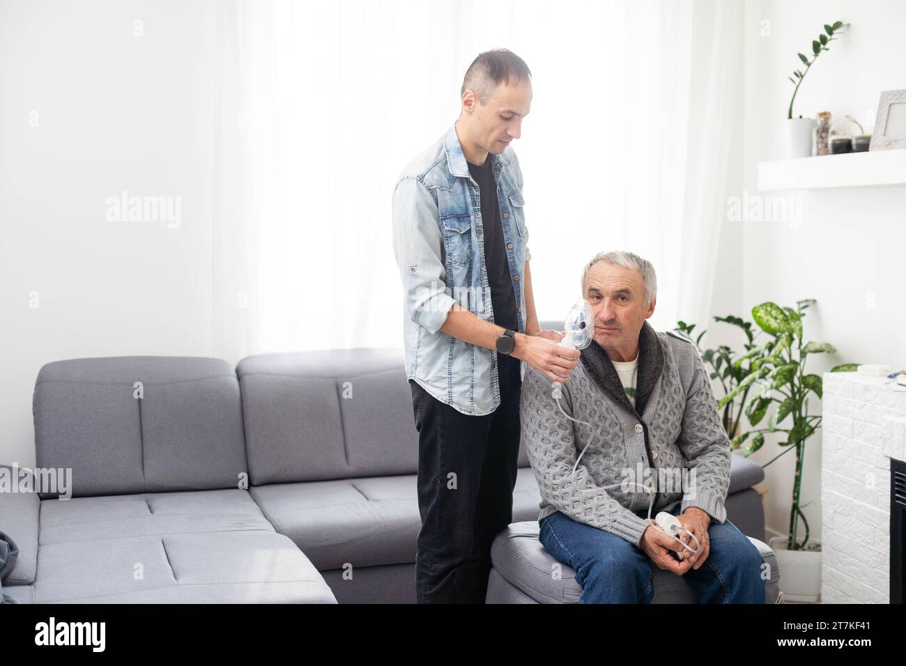 Elderly son takes care of ill father Stock Photo - Alamy