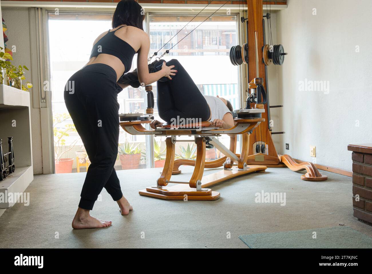Latina female instructor standing teaching correct leg posture to ...