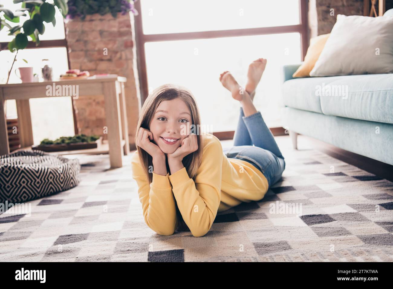 Portrait of cheerful young girl teenager lying carpet touch cheeks ...