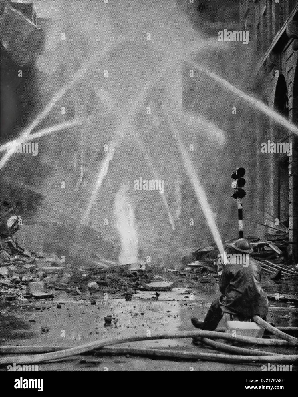 A fireman in action spraying water on a burning building in London ...