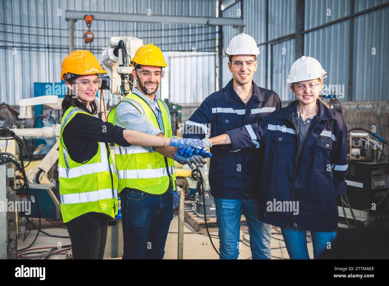 Engineers team mechanic making pile of hands in steel factory workshop ...