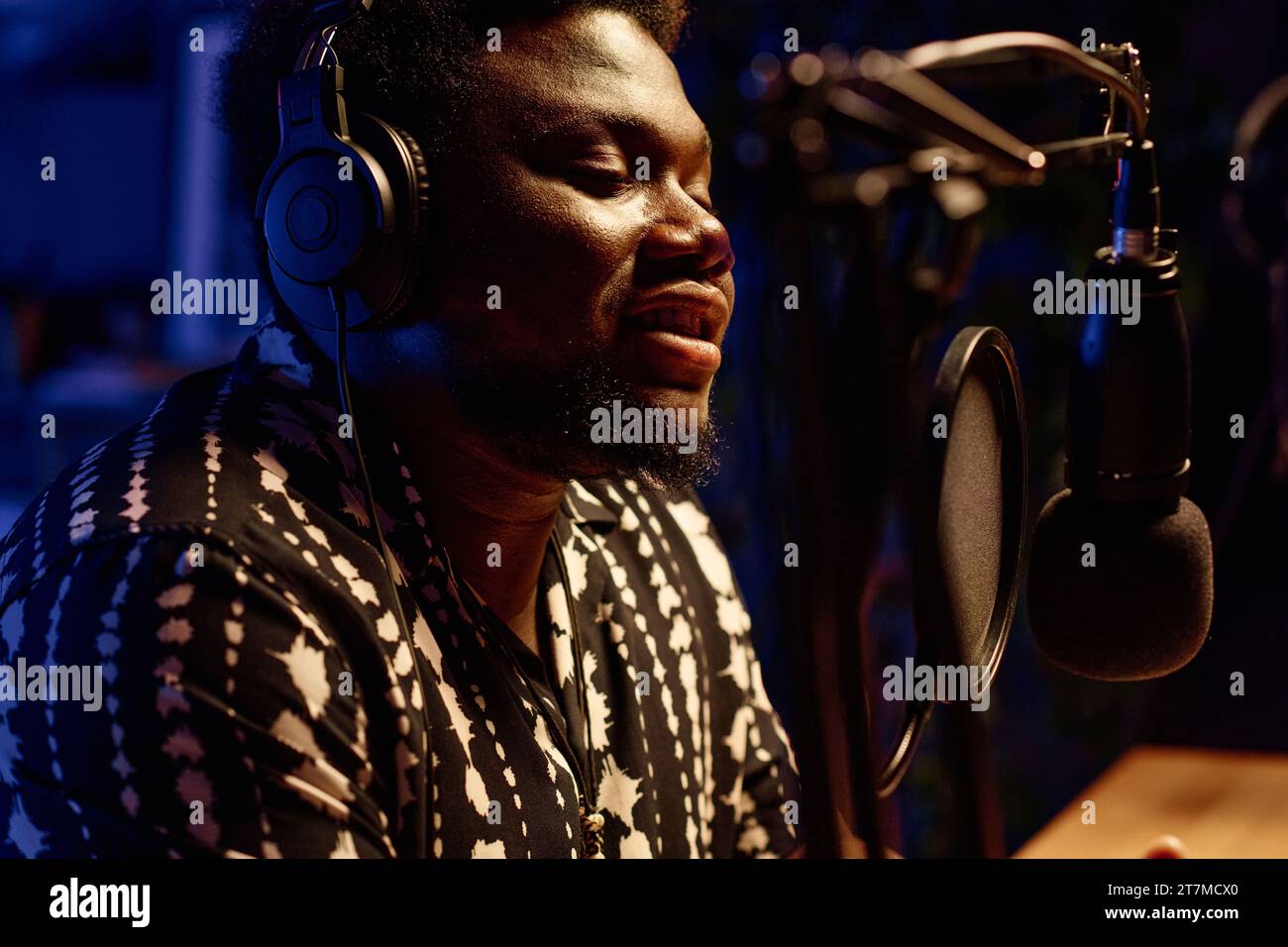 African American guy in headphones talking or whispering in microphone ...