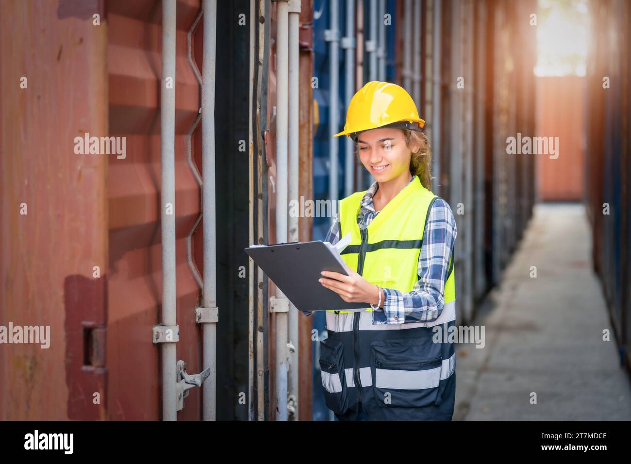 Women Engineer wears PPE checking container storage with cargo ...