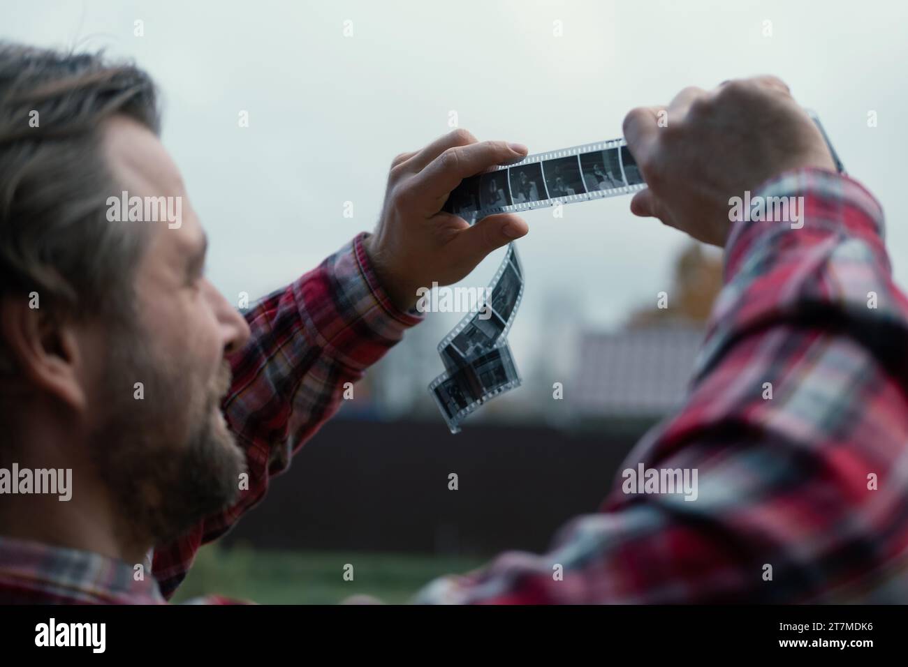 Man looks with interest at a vintage photographic film. Concept of ...