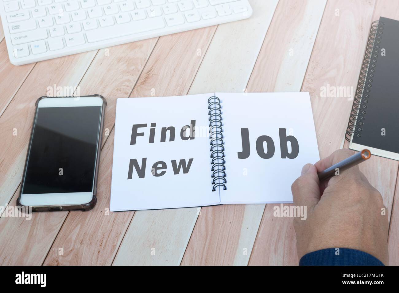 Businessman hands with pen writing words FIND NEW JOB on a notebook ...