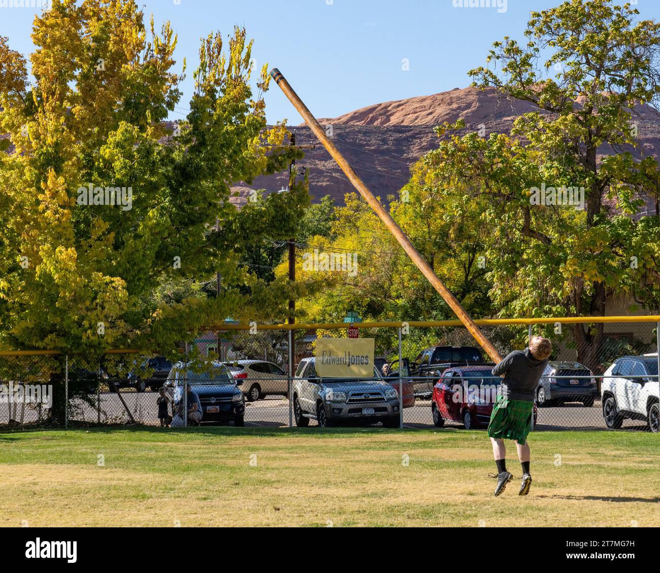 A competitor in a kilt tosses the caber in the Highland games at the ...