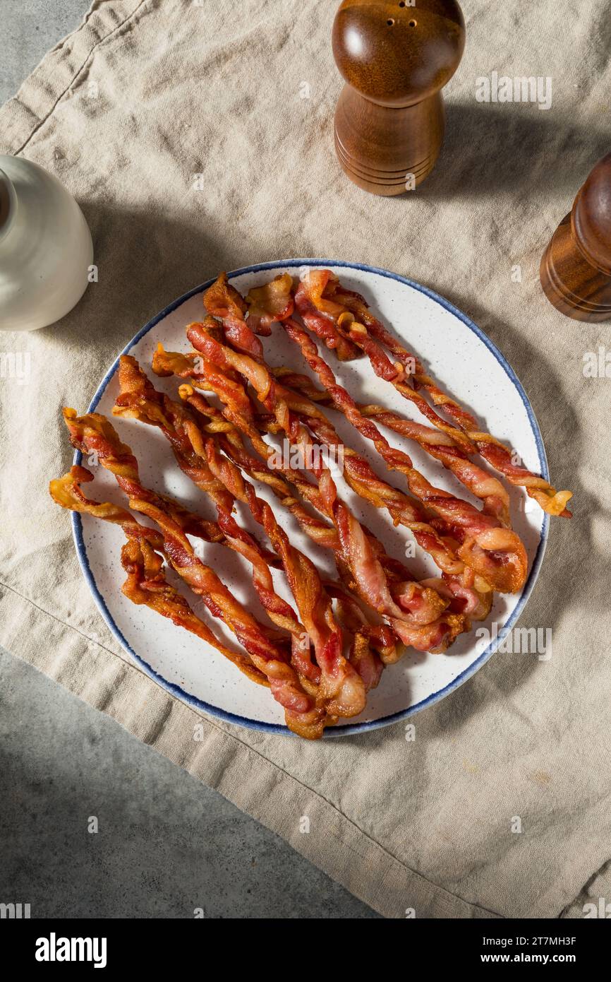 Homemade Trendy Twisted Bacon Strips on a Plate Stock Photo - Alamy