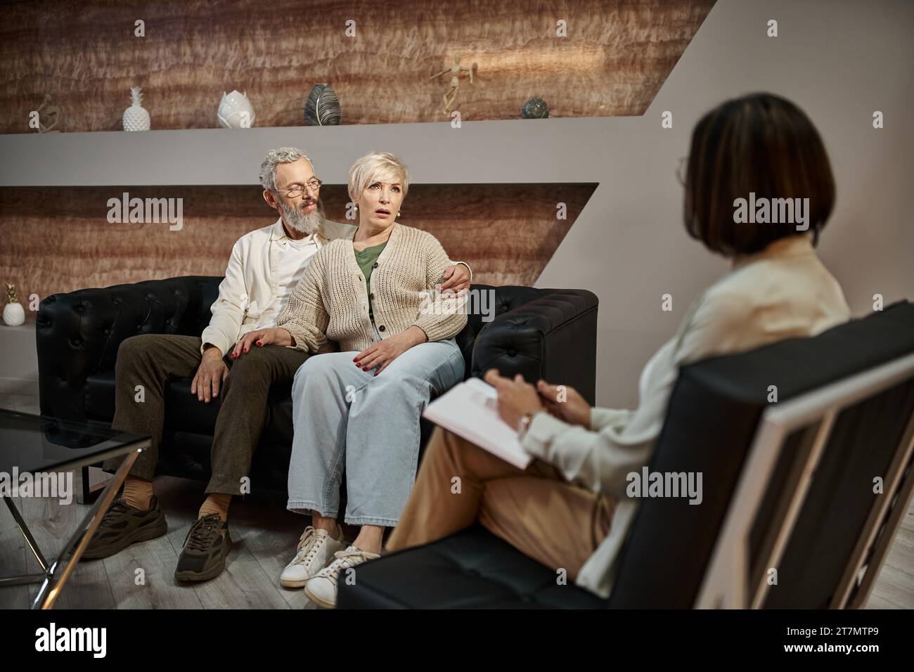 bearded man hugging worried middle aged wife during therapy session ...