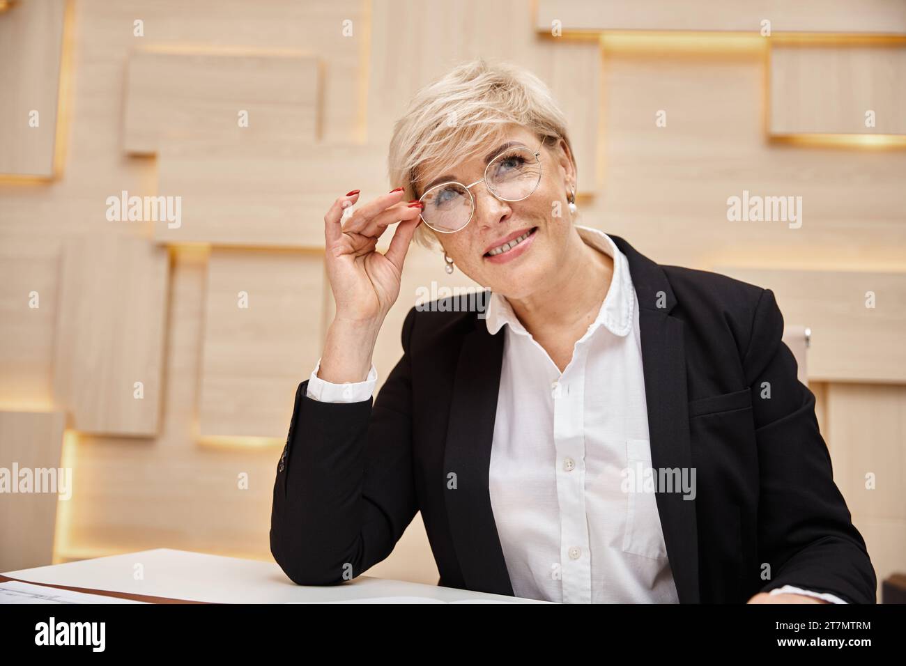 happy blonde middle aged realtor in eyeglasses working in real estate ...