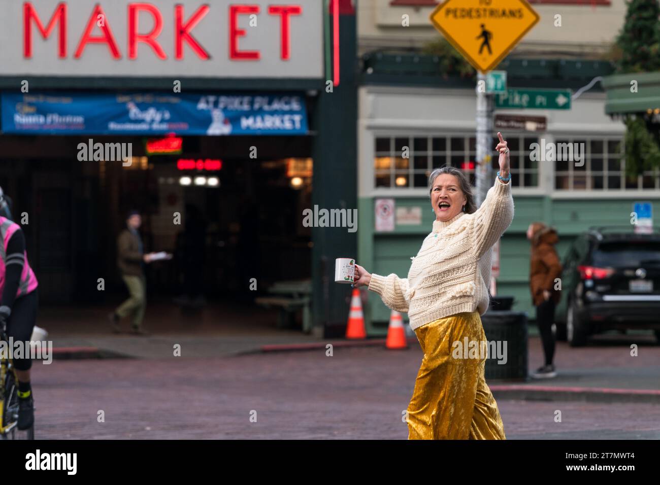 Seattle, USA. 16th Nov 2023. A woman gestures across the street from ...