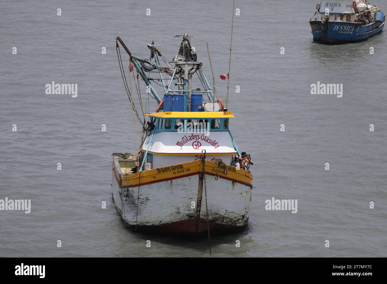 Two small fishing boats with outboard motors are floating in a calm and ...