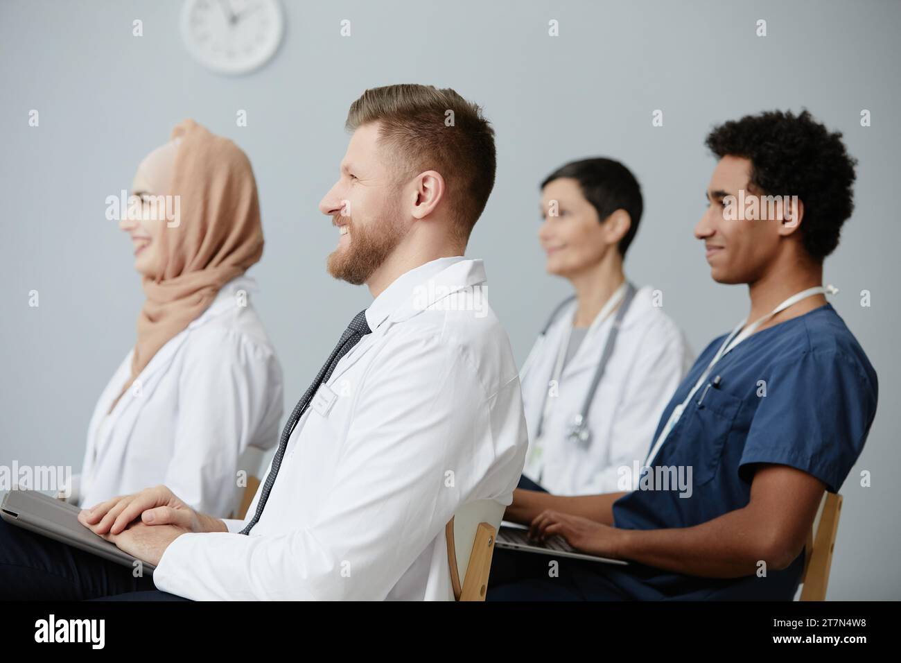 Minimal side view at diverse group of people sitting in audience and ...