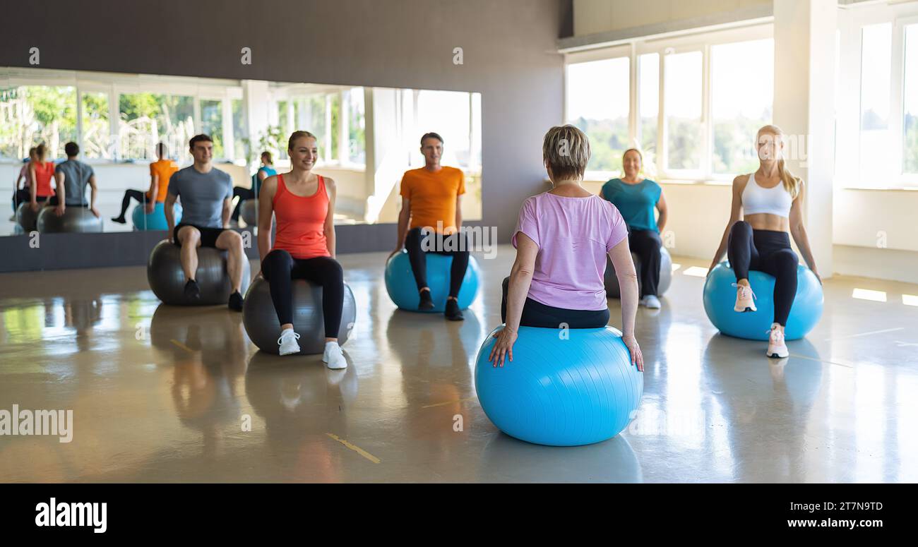 Group of diverse people from behind in a receding line doing pilates in ...