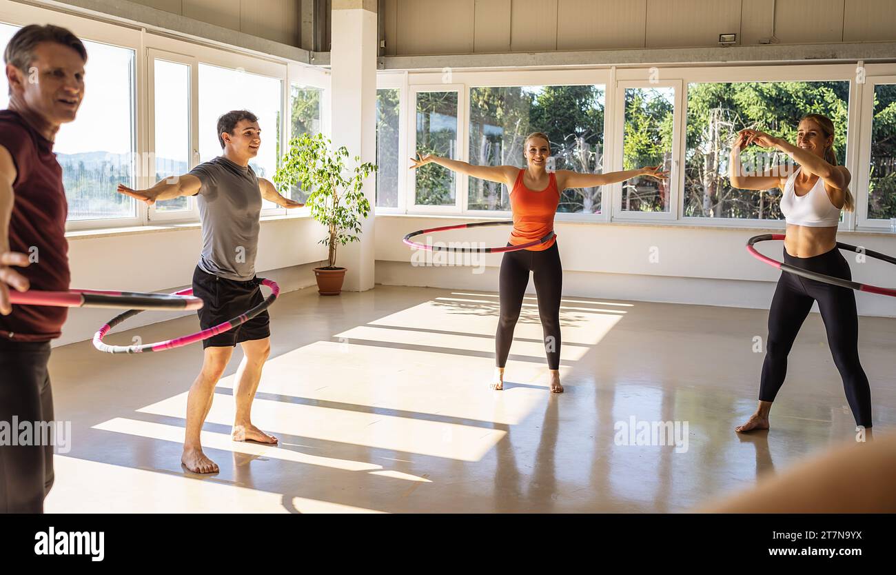 Team Sport group of people doing hula hoop in step waist hooping ...