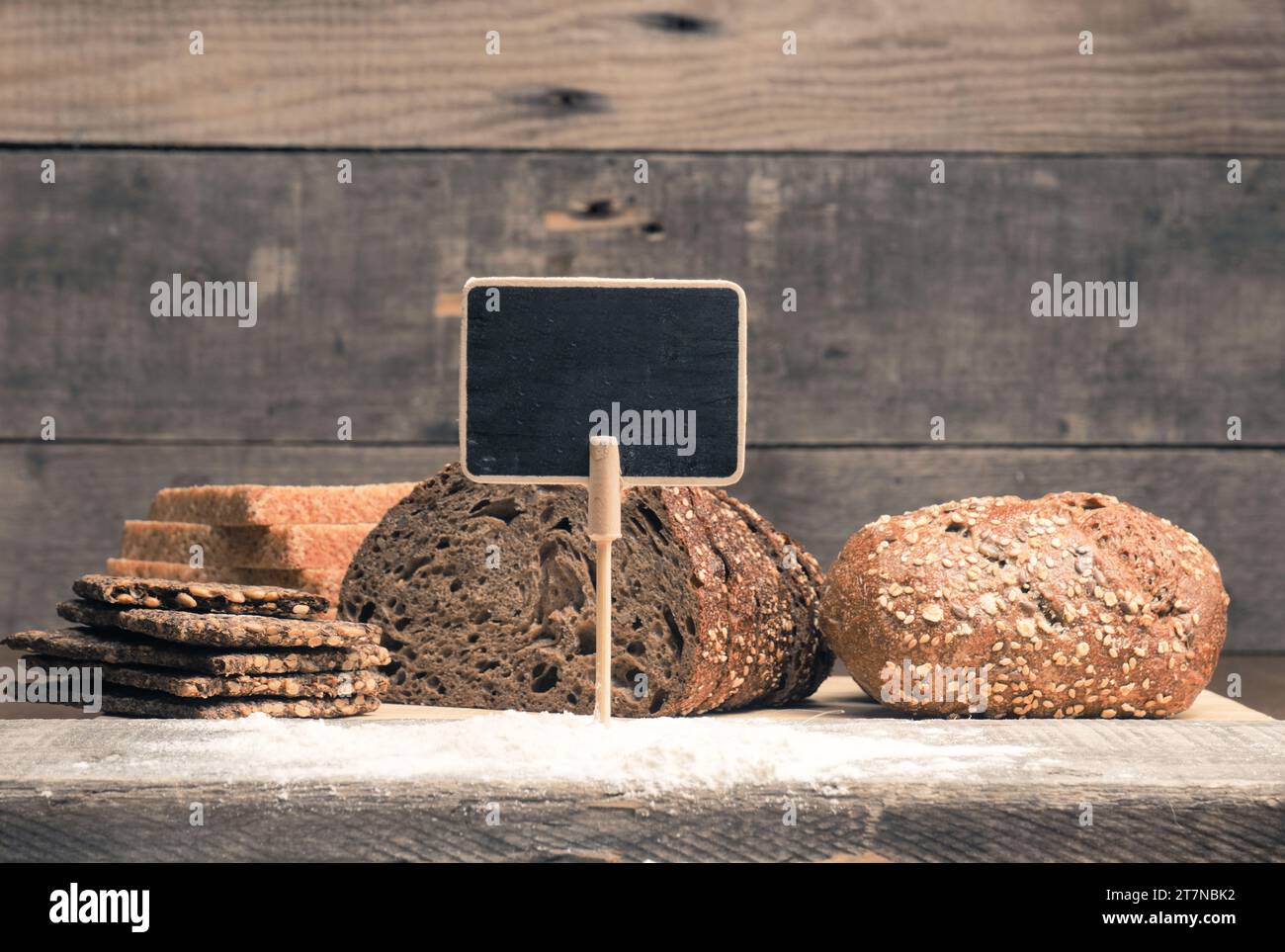 A small blank chalkboard with different types of bread as decoration ...