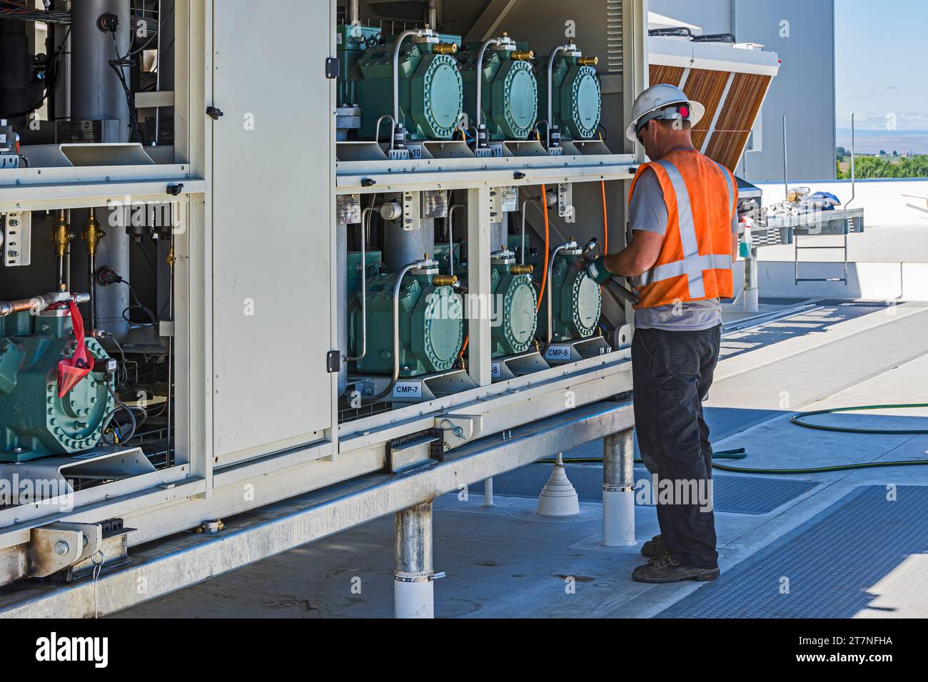 Construction worker tightens a fitting in a compressor housing with ...