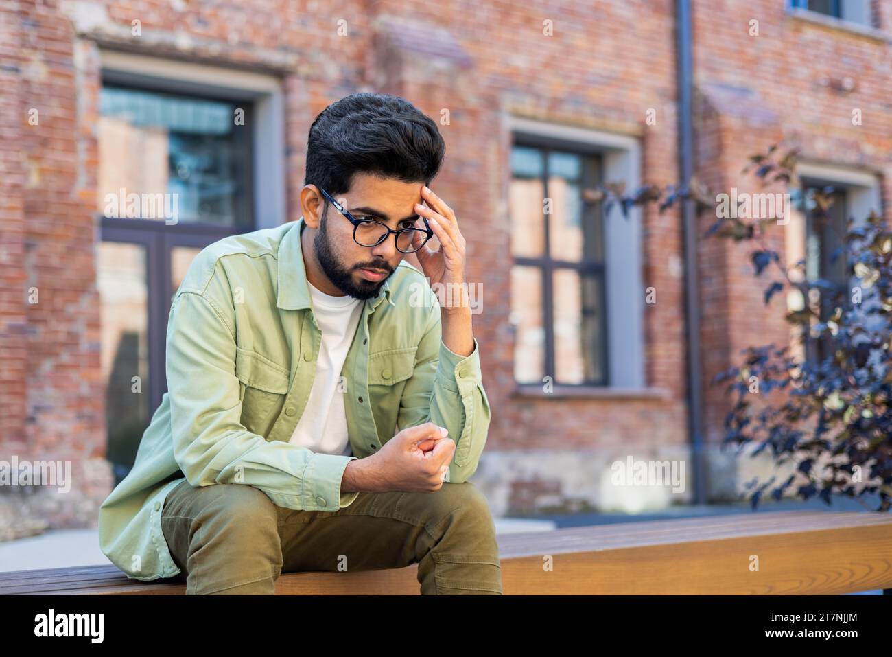 Worried man sitting alone outdoors hi-res stock photography and images ...